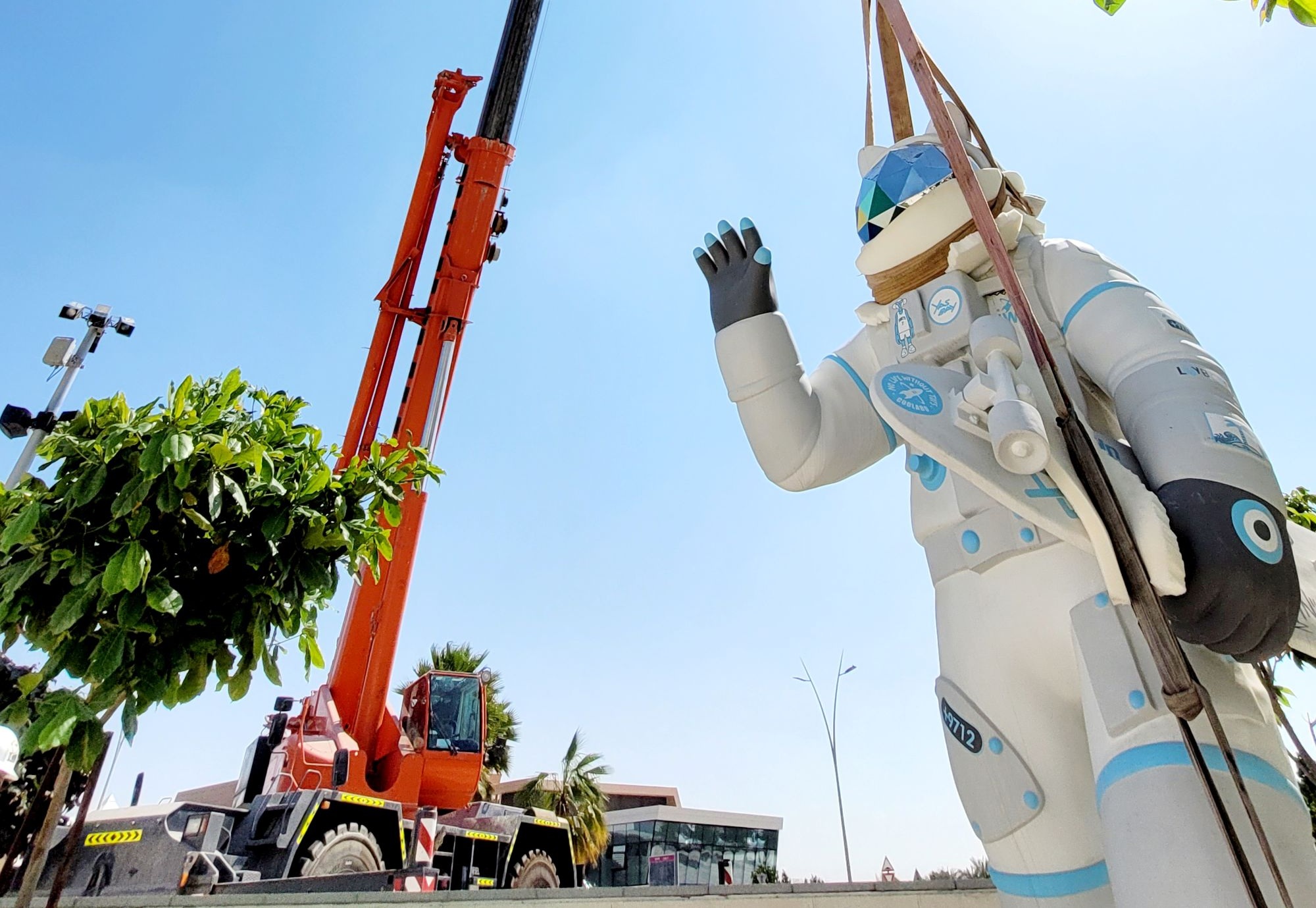 Crane is lifting an astronaut statue - Johnson Arabia LLC