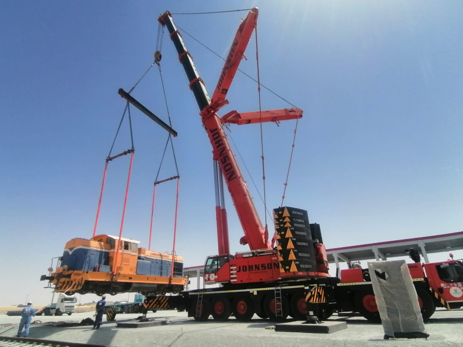 Crane is lifting a train on the Etihad Railway - Johnson Arabia LLC